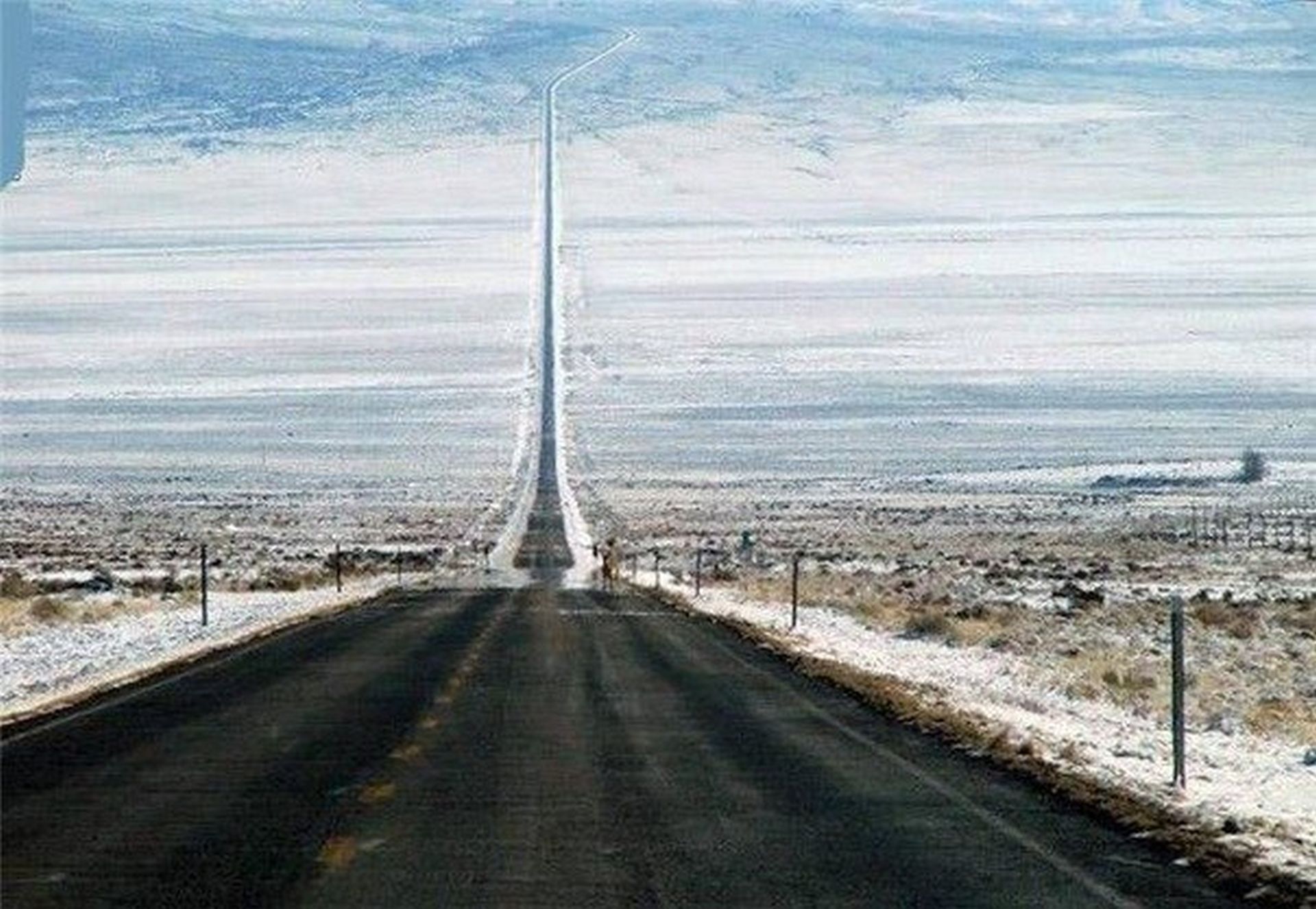 Endless Horizons: A Man-Made Road Through Snowy Landscapes