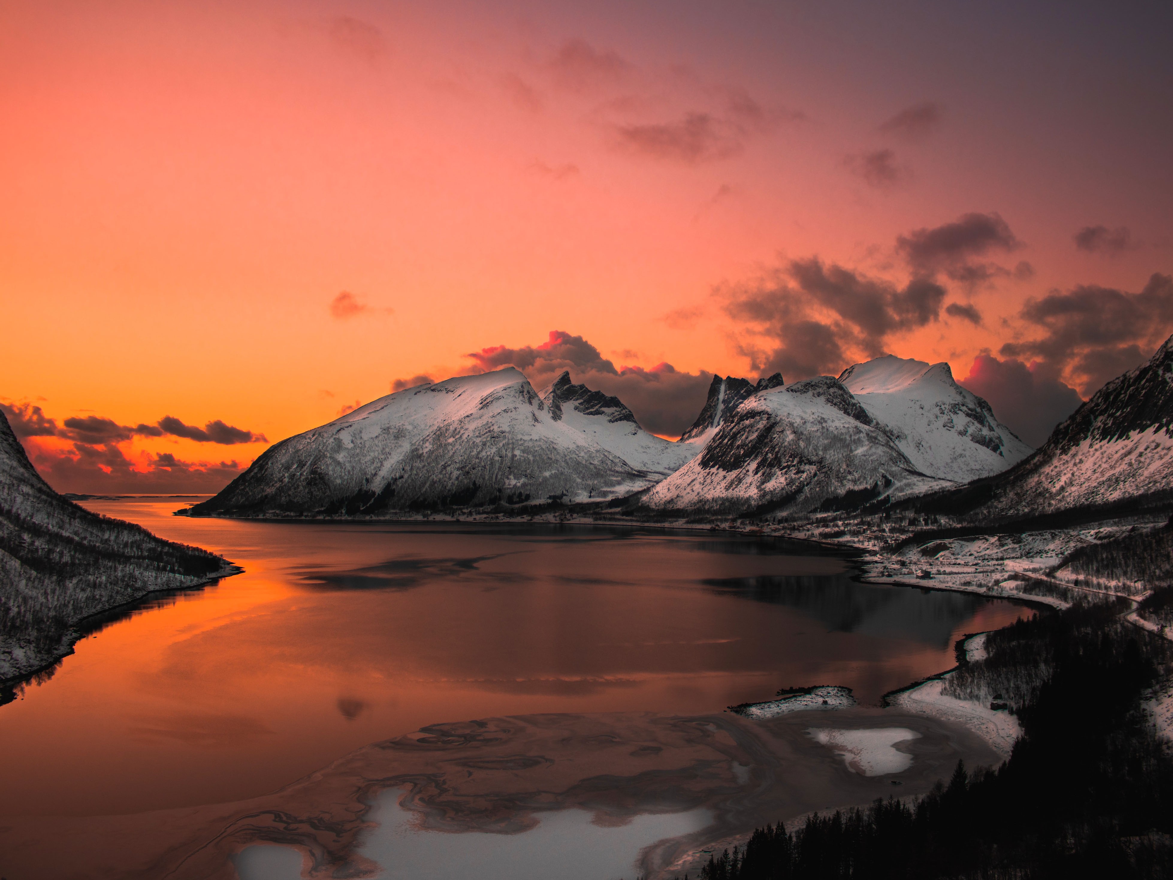Snow-Capped Peaks Reflecting Over a Serene Mountain Lake at Sunset