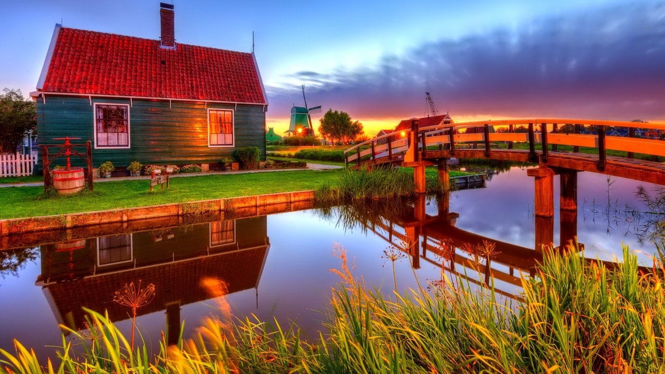 Charming HDR Scene of a Bridge, Windmill, and House at Sunset
