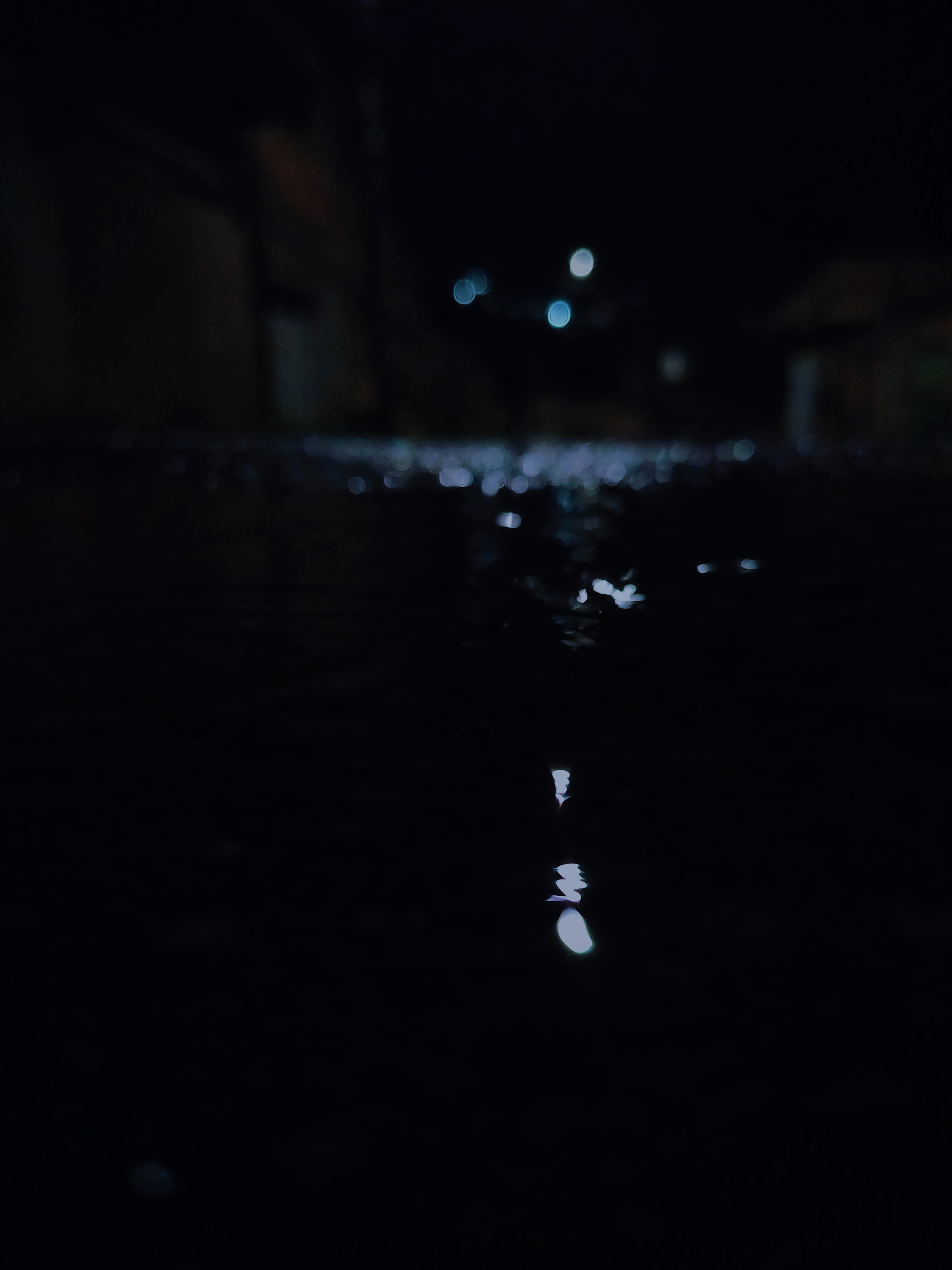 Reflection of light in a puddle of water on the street. by Hermano006