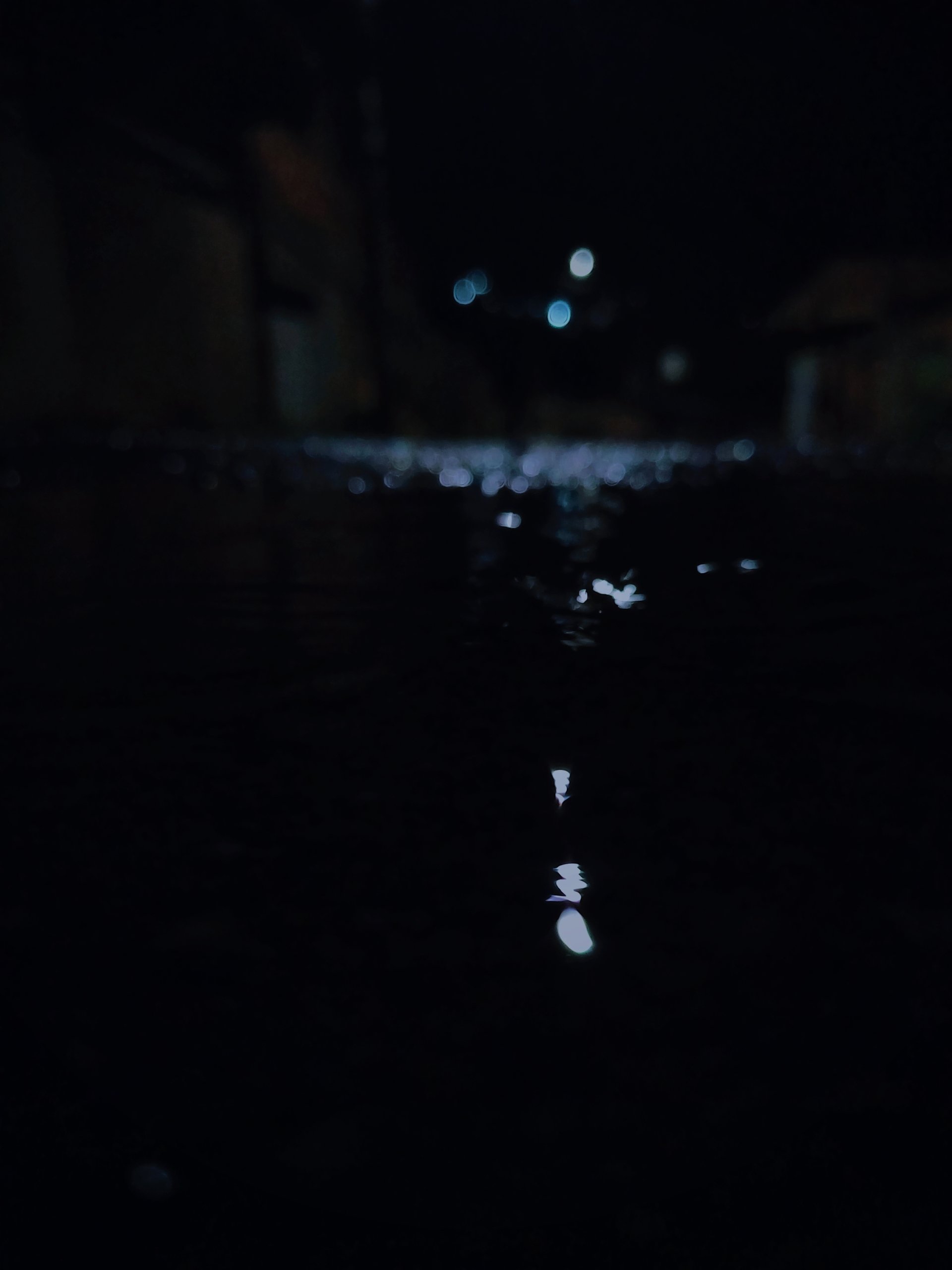 Reflection of light in a puddle of water on the street. by Hermano006